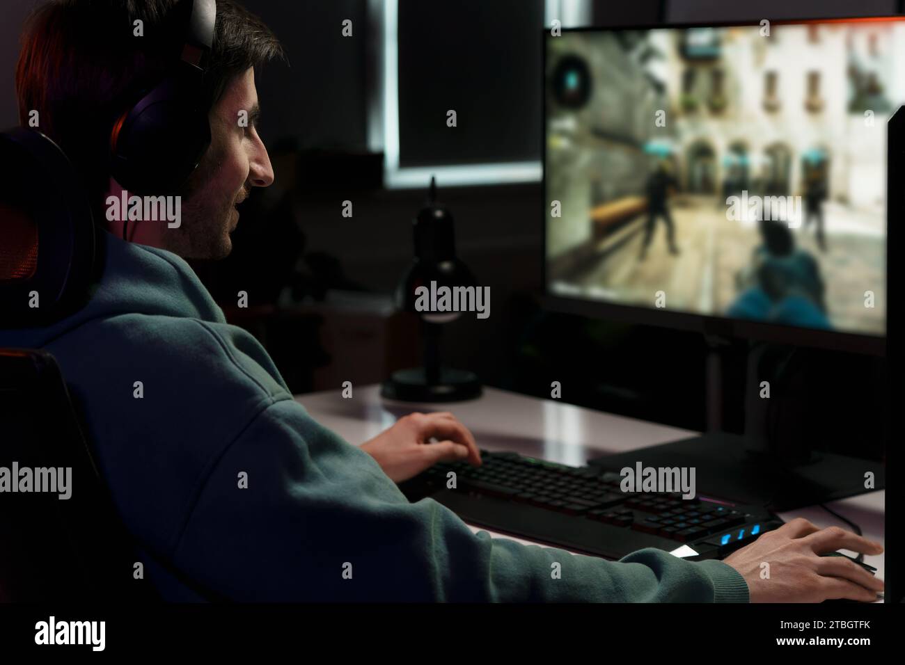 Male gamer wearing headset while gaming at home Stock Photo - Alamy
