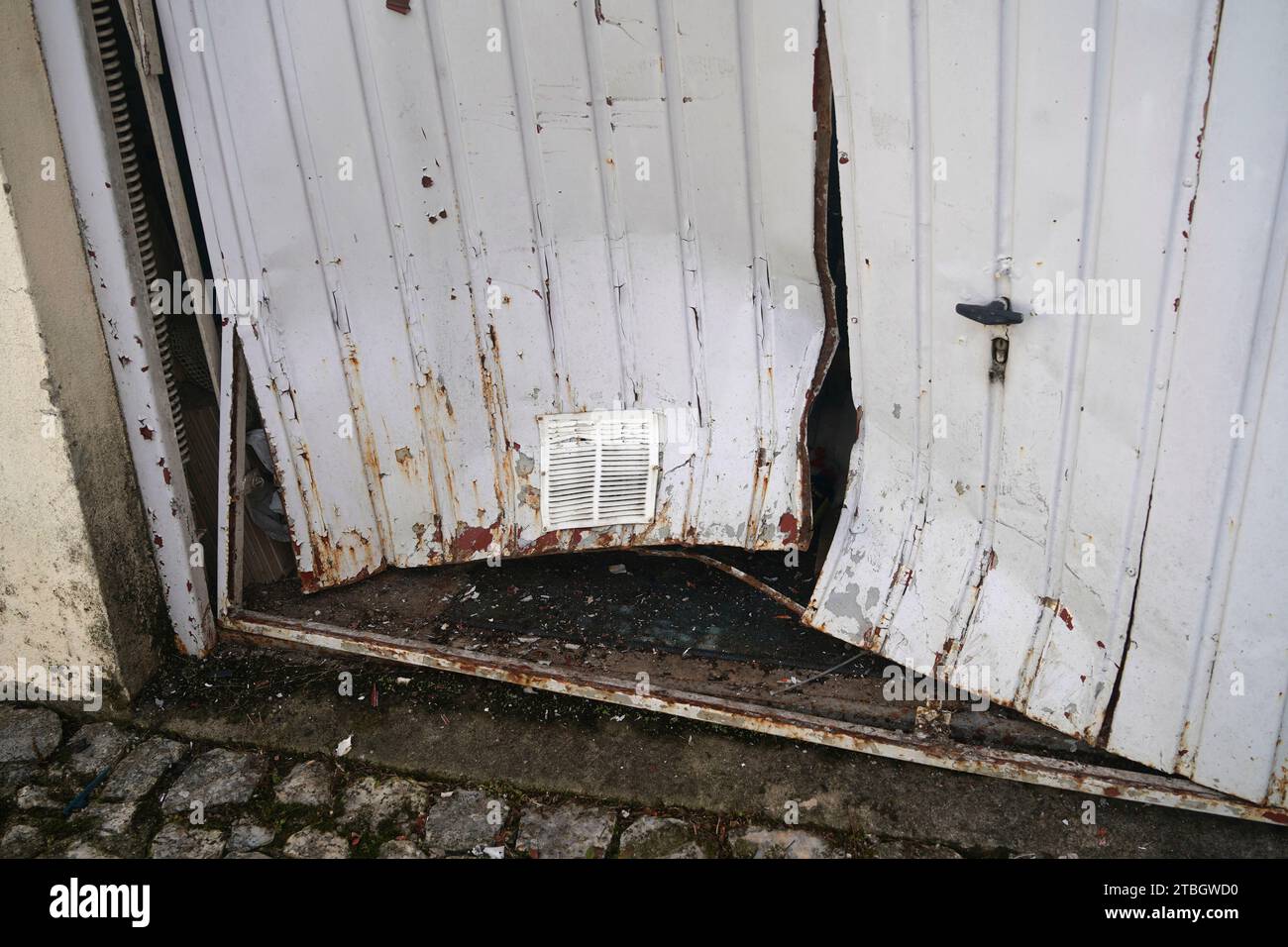 Damaged up and over garage door Stock Photo - Alamy