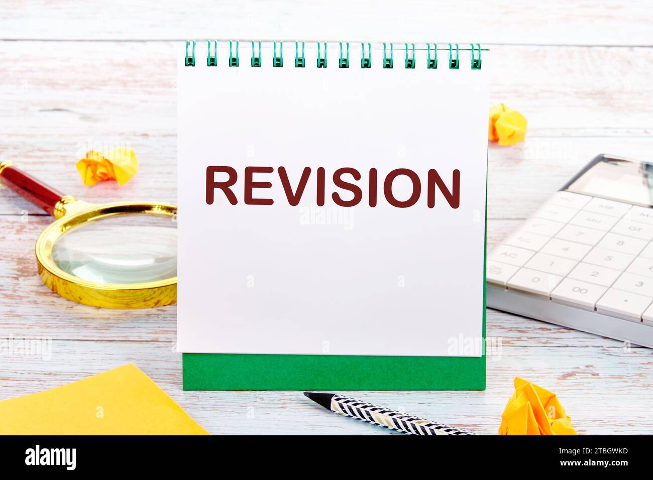 REVISION text on the white sheet of the notebook is next to a ...