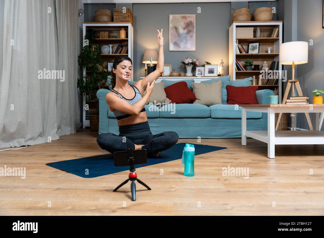 Attractive young woman learning new exercises watching online workout ...