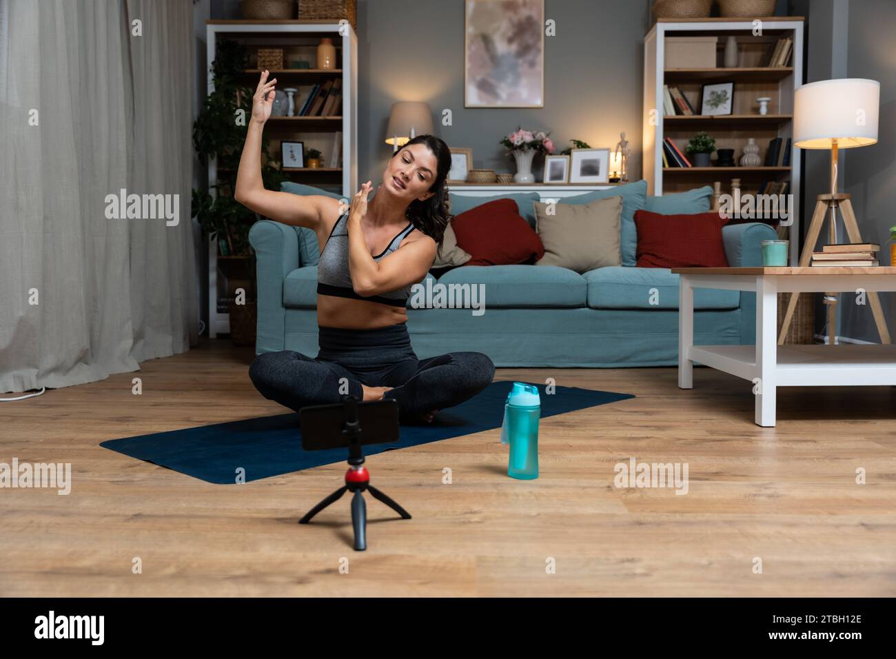 Attractive young woman learning new exercises watching online workout ...