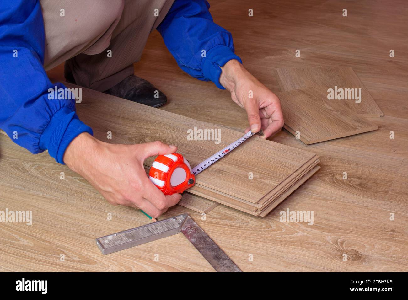 Measuring the laminate board using Tape measure, Worker's hands are ...