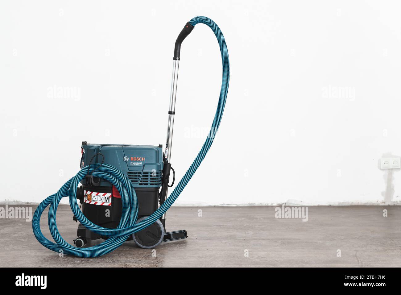 Professional construction vacuum cleaner in an empty room with white ...