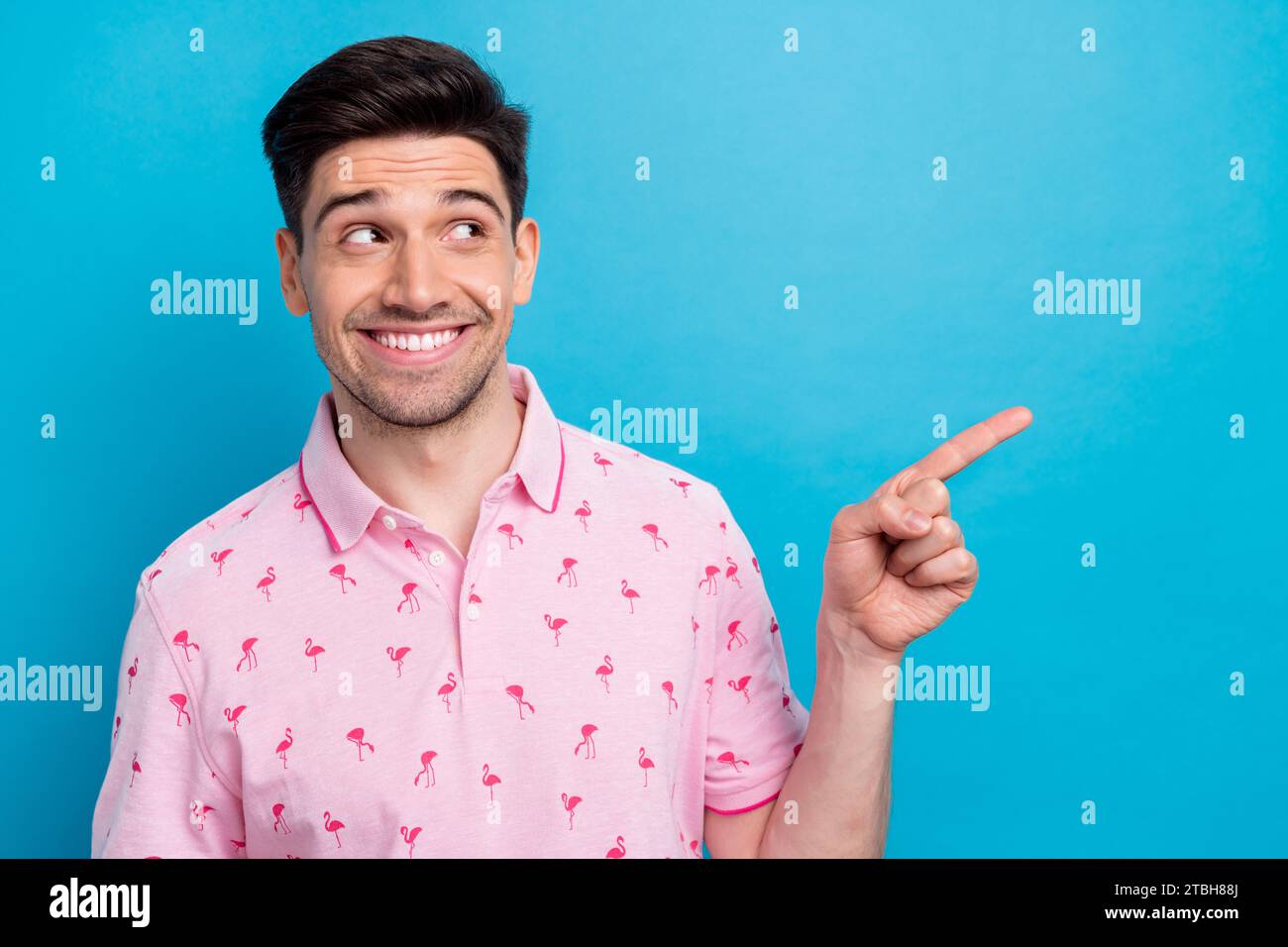 Portrait of positive satisfied man beaming smile look indicate finger ...