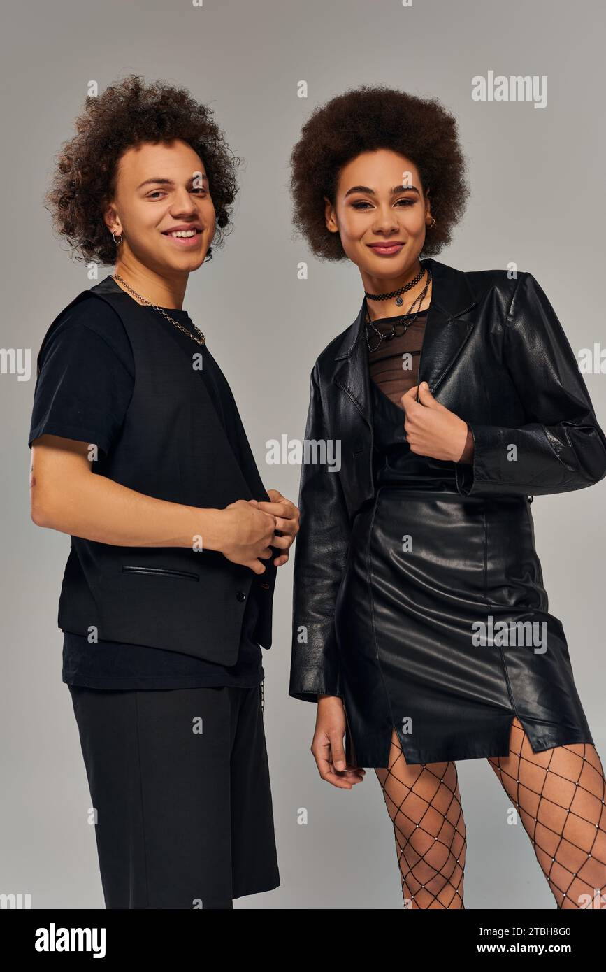 joyful african american siblings in stylish black urban attire posing ...