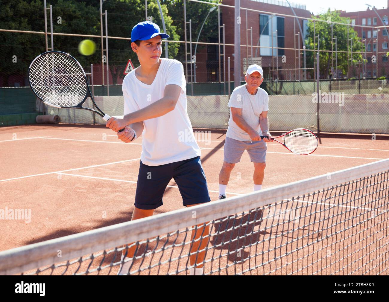 Tennis players of different generations playing tennis court Stock ...