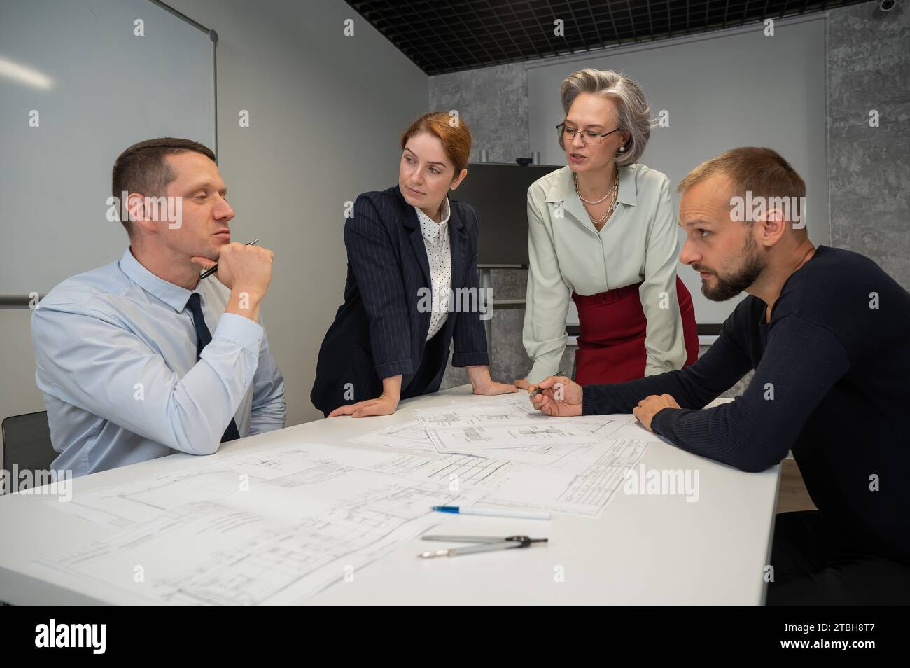 Designers engineers at a meeting discuss working drawings Stock Photo ...