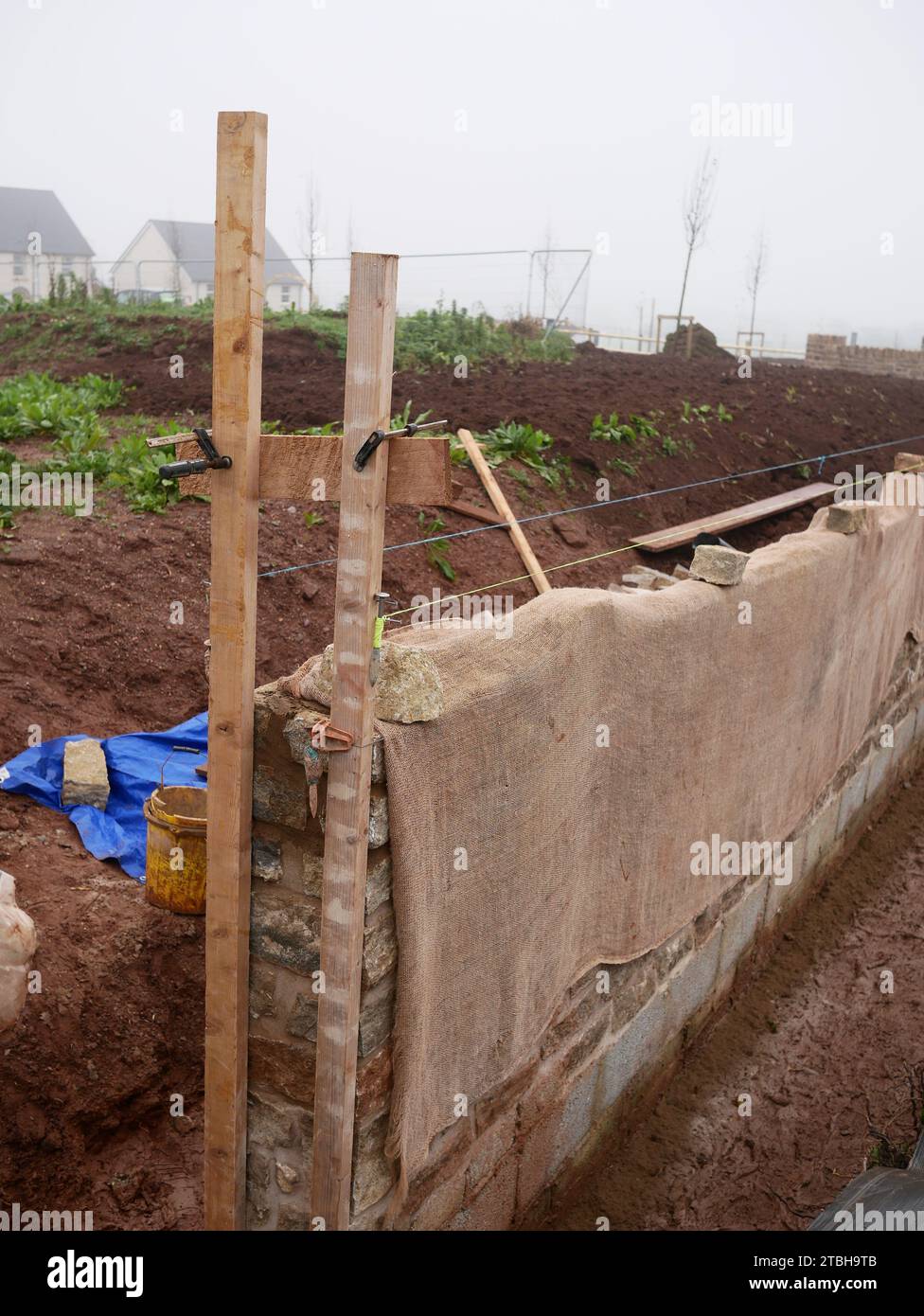 Boundary wall with traditional stone facing being constructed at a new ...