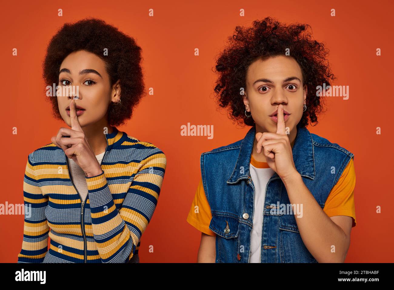 young african american brother and sister showing hush and looking at ...