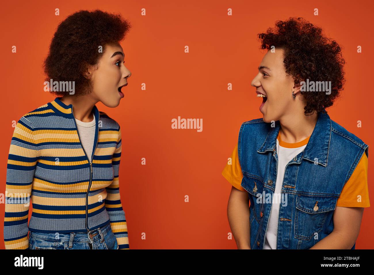 amazed young african american siblings in casual outfits looking ...