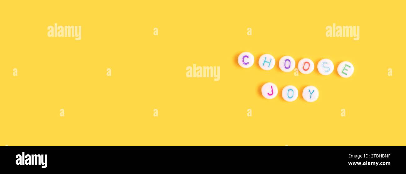 Choose joy. Banner with quote made of beads with letters on a yellow ...