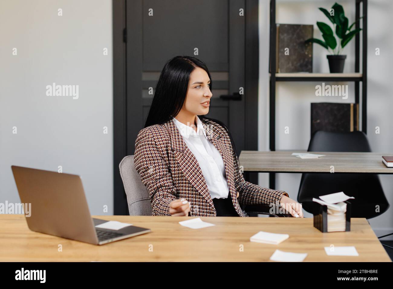 Young happy excited business woman in suit sitting at office desk with ...