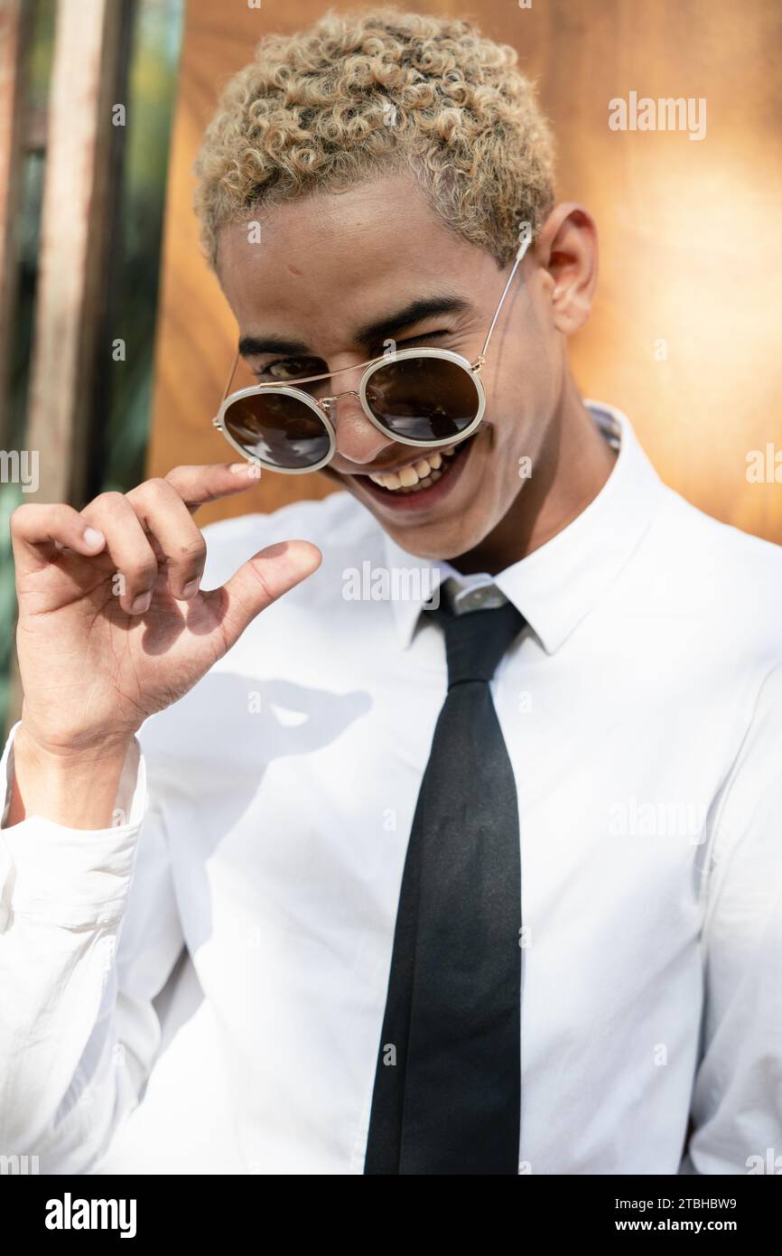Portrait of modern beautiful young man smiling with glasses and ...