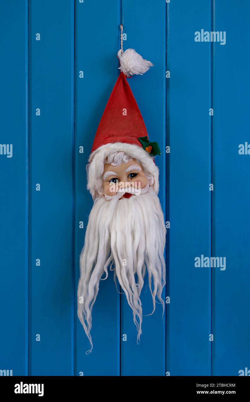 Red santa face with white beard hanging on vibrant blue wooden door ...