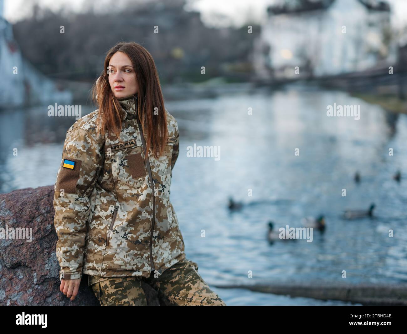 Ukrainian woman soldier resting in park during vacation near lake ...