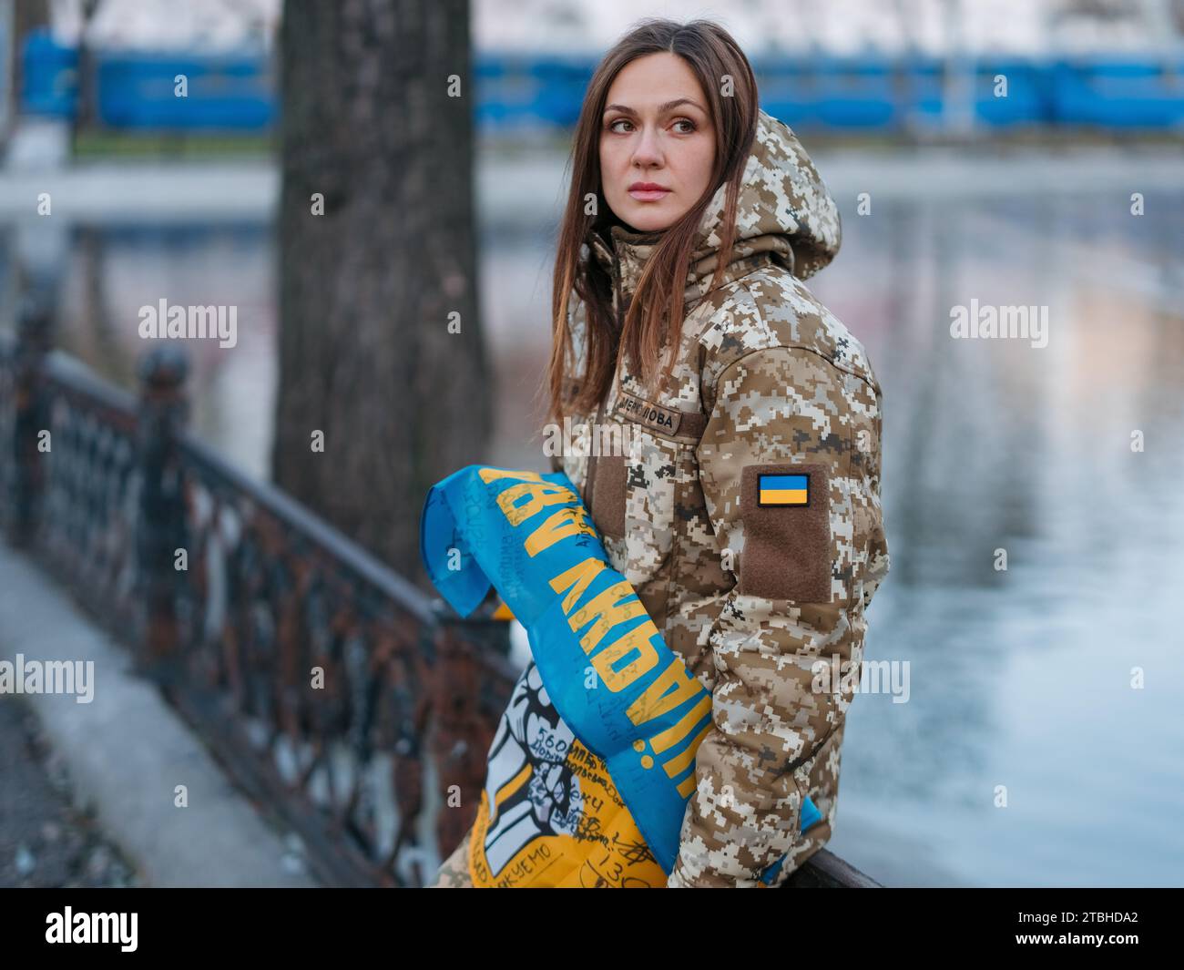 Ukrainian woman soldier holding flag with signatures of Ukrainian ...