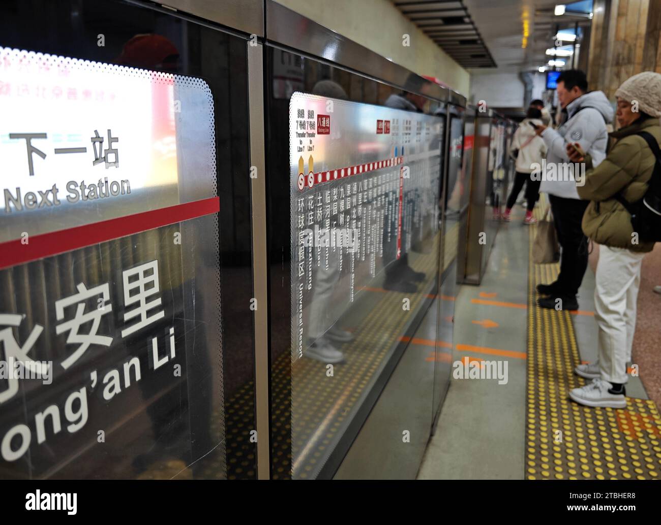 BEIJING, CHINA - DECEMBER 7, 2023 - Passengers wait under a bilingual ...