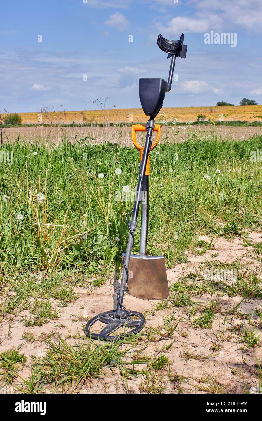Crossed shovel and magnetic metal detector against the backdrop of a ...