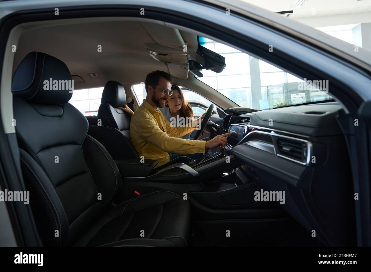 Young couple choosing auto in car showroom Stock Photo - Alamy