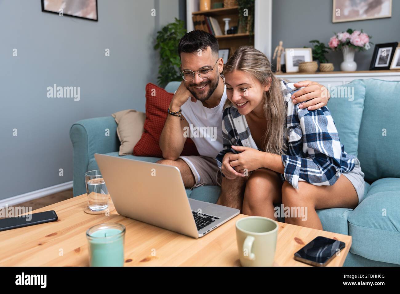 Happy young couple at home man surprise woman to choose travel ...