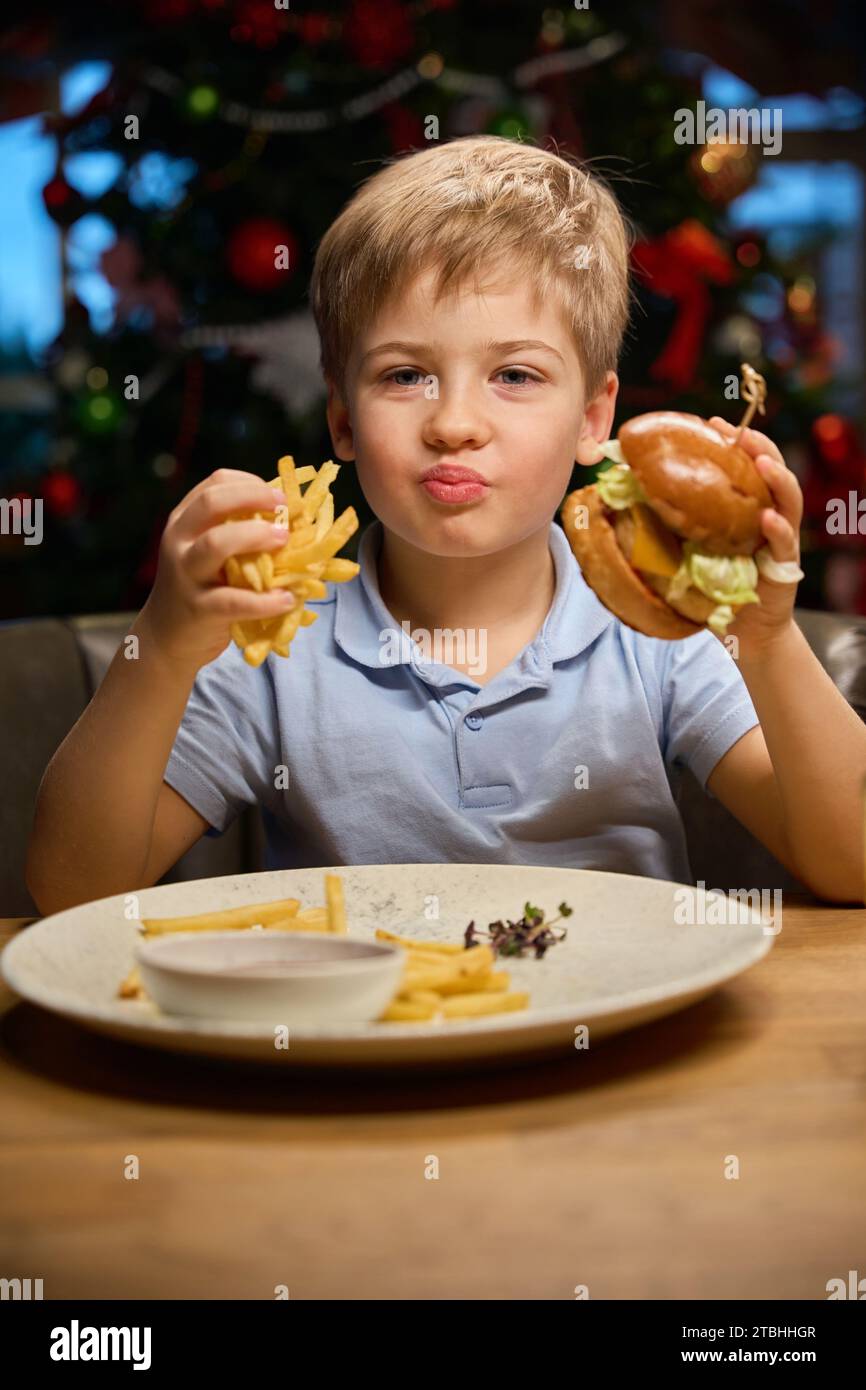 Little boy eating delicious sandwich at festive dinner celebrating New ...