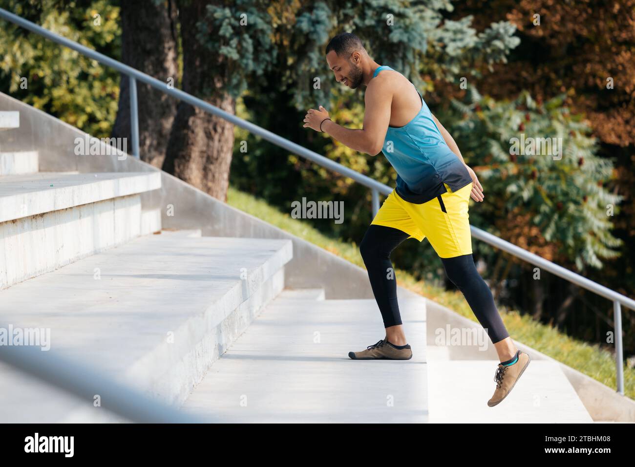 Dark-skinned sportsman running on the stairs during workout Stock Photo ...