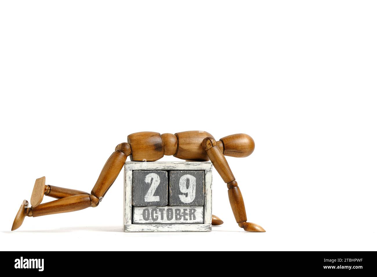 October 29, wooden calendar with mannequin lying on it on white ...