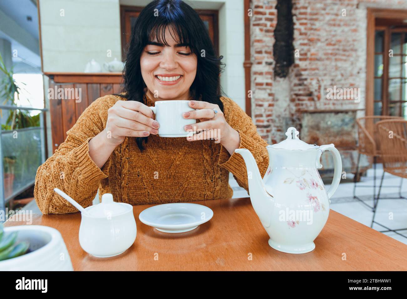 young black-haired Venezuelan woman happy smiling is sitting in ...
