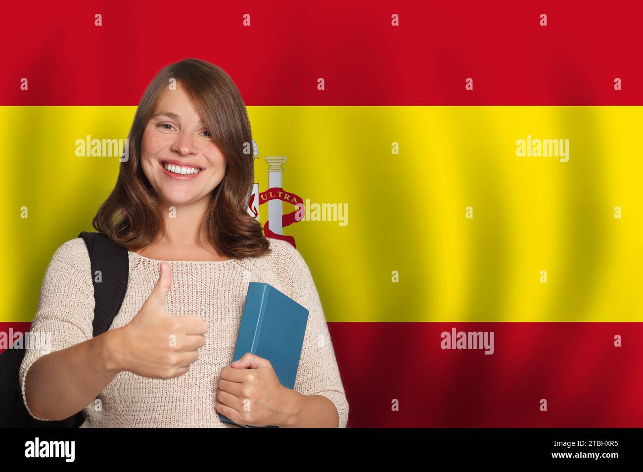 Beautiful woman student against Spanish flag background. Travel ...