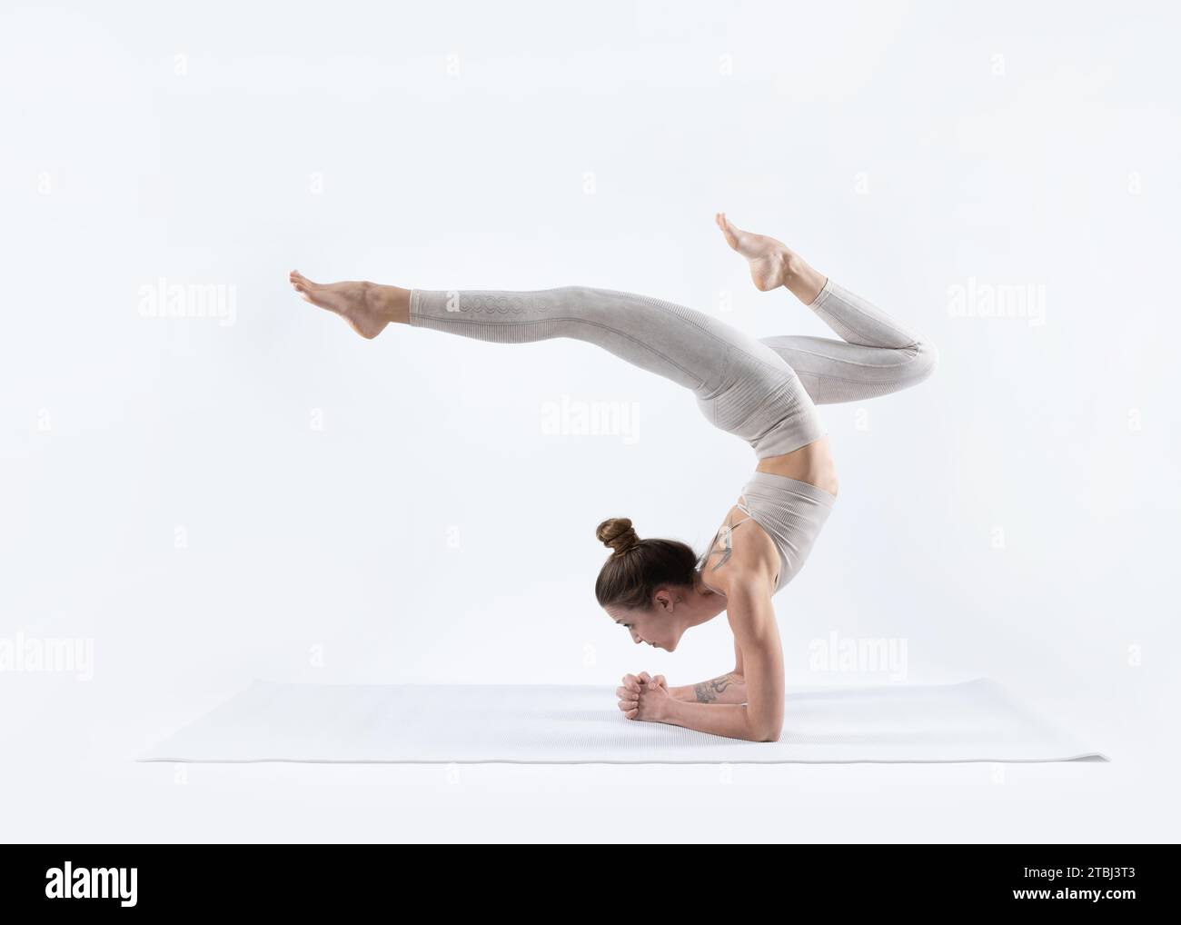 beautiful young athletic woman doing pincha mayurasana (forearm stand ...