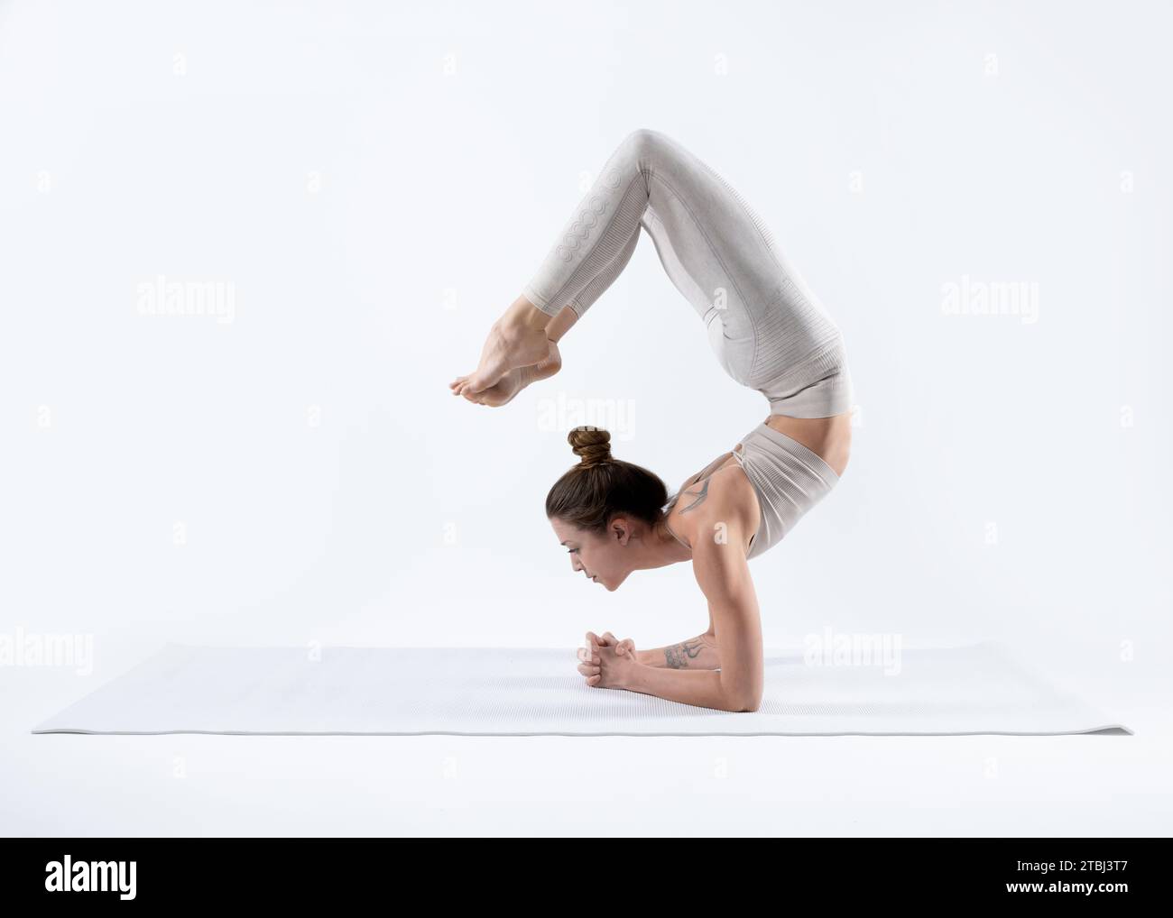beautiful young athletic woman doing pincha mayurasana (forearm stand ...