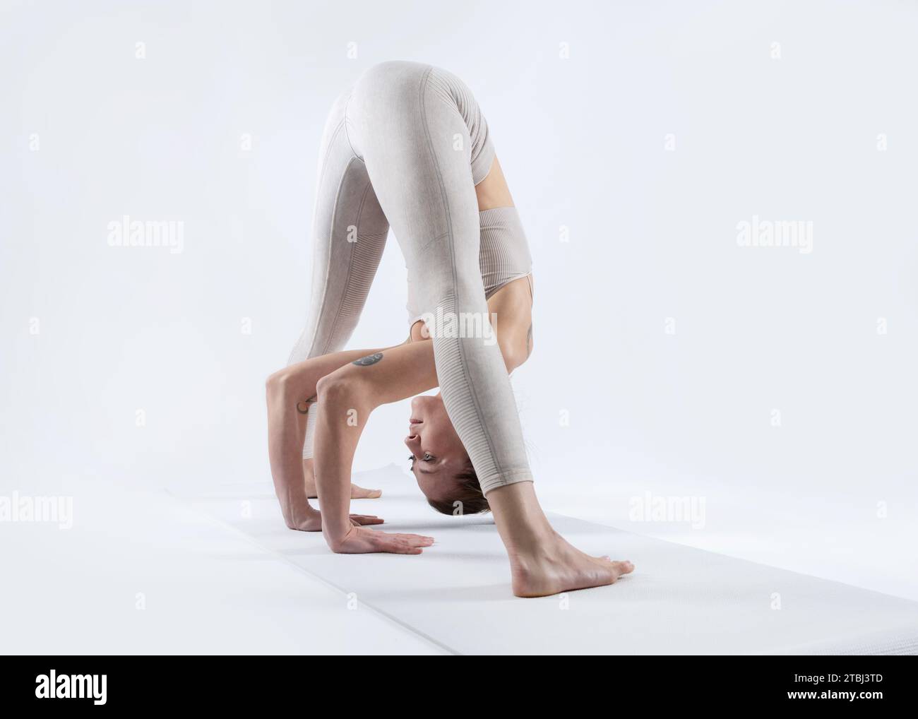 beautiful young athletic woman doing prasarita padottanansana (wide ...