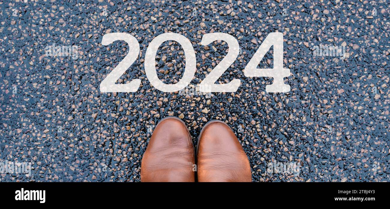 New year 2024 is standing on the road, feet in shoes on ground calendar ...