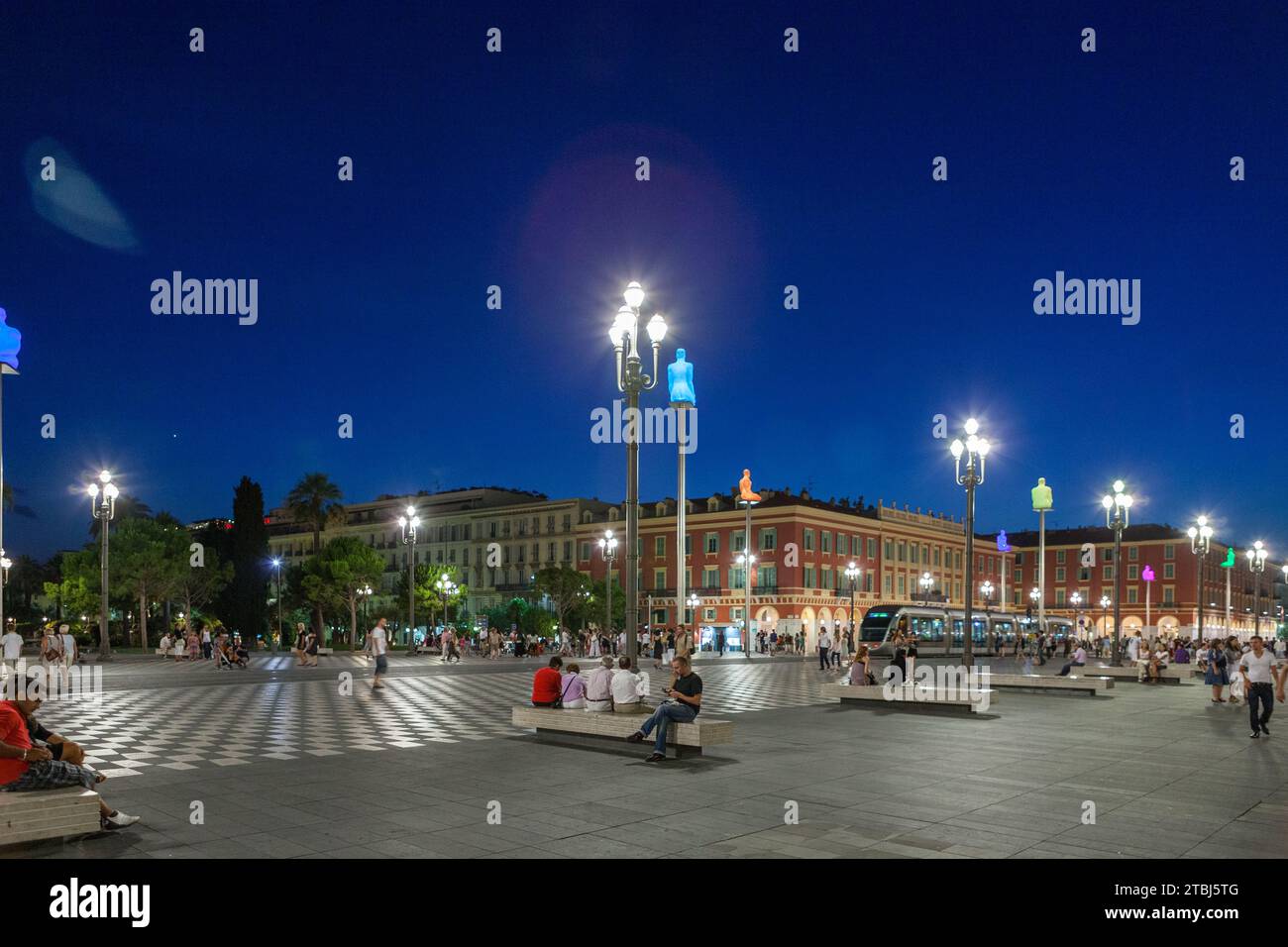 Statues of men atop poles, Place Masséna in the evening, Nice, France ...