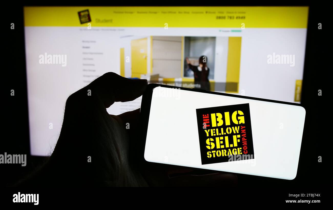 Person holding mobile phone with logo of British self-storage company ...