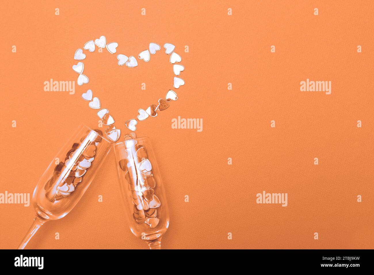 Glass of champagne with hearts on Peach Fuzz background. Valentines ...
