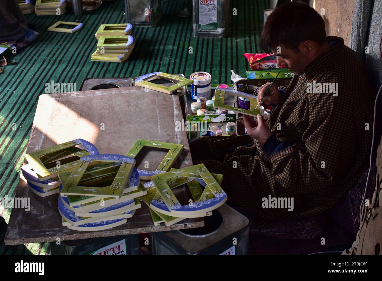 A Kashmiri artisan makes the final touches on a papier-mache product ...