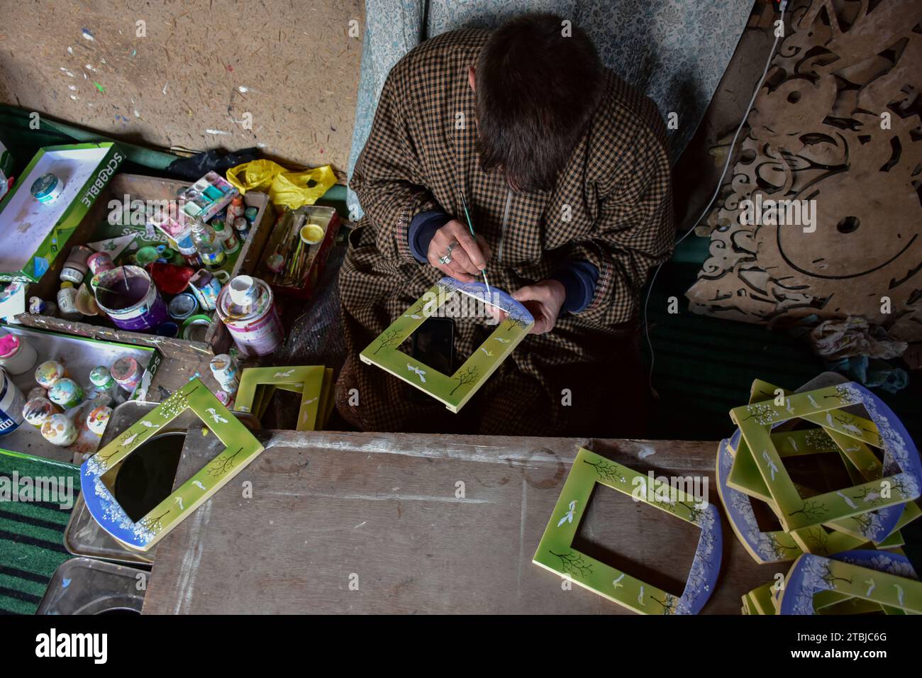 A Kashmiri artisan makes the final touches on a papier-mache product ...
