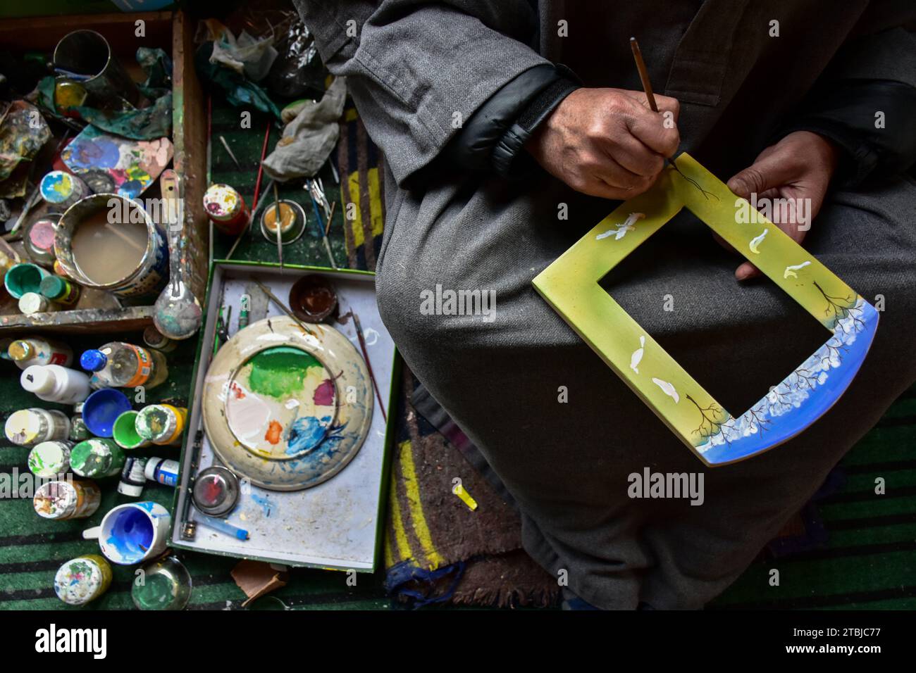 A Kashmiri artisan makes the final touches on a papier-mache product ...