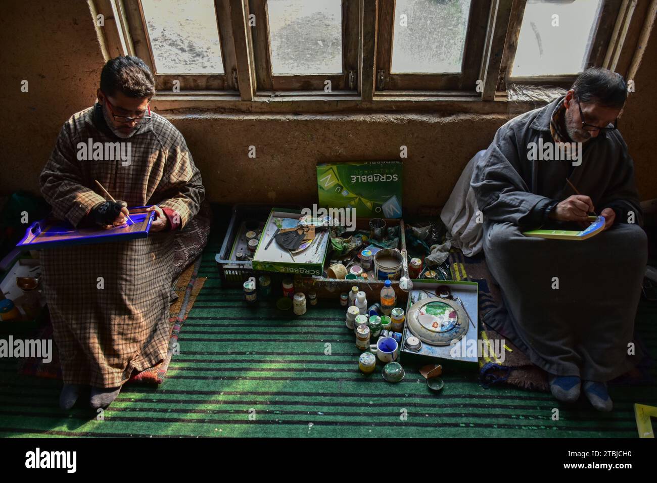 Kashmiri artisans make the final touches on a papier-mache product ...