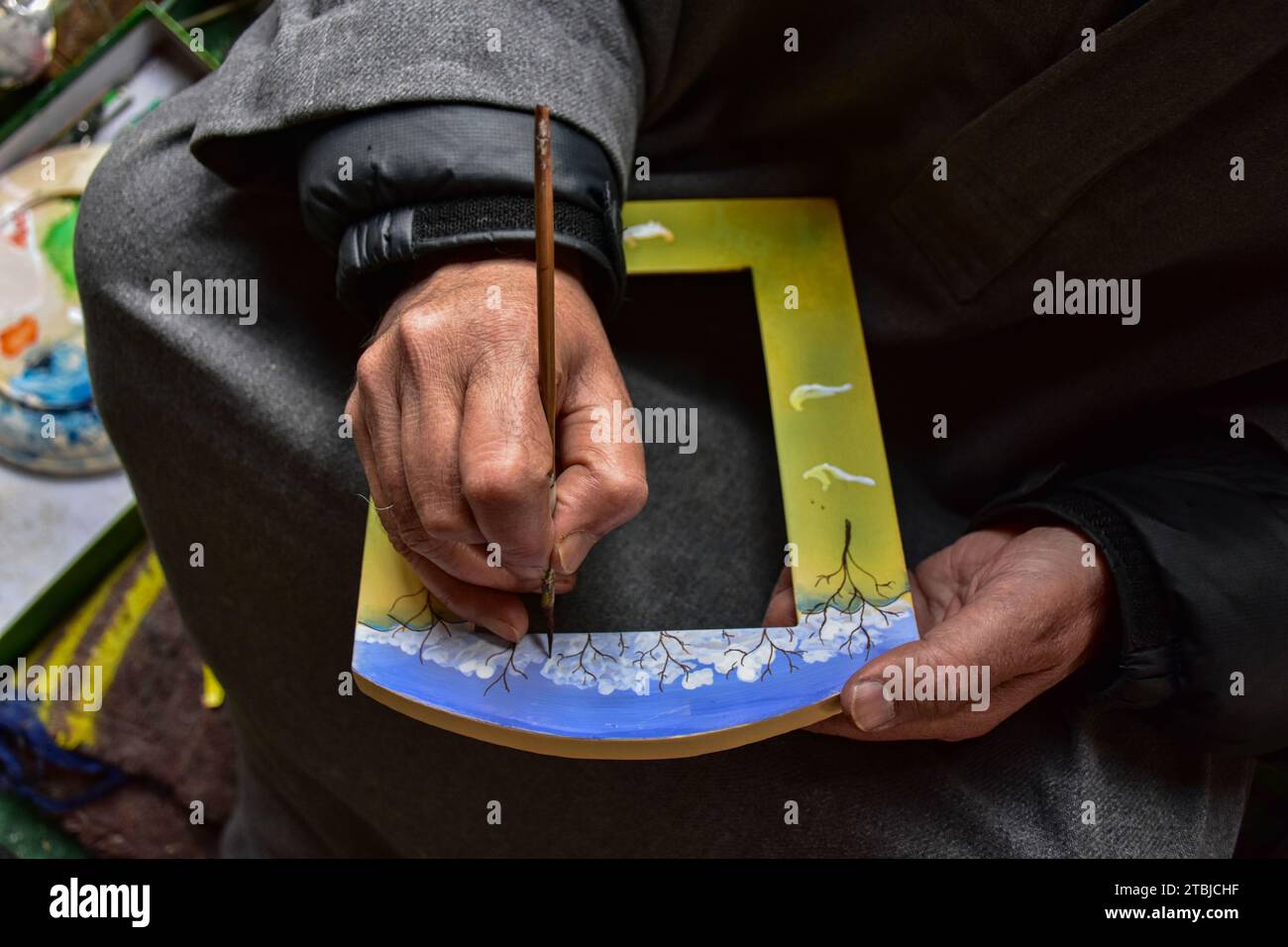 A Kashmiri artisan makes the final touches on a papier-mache product ...
