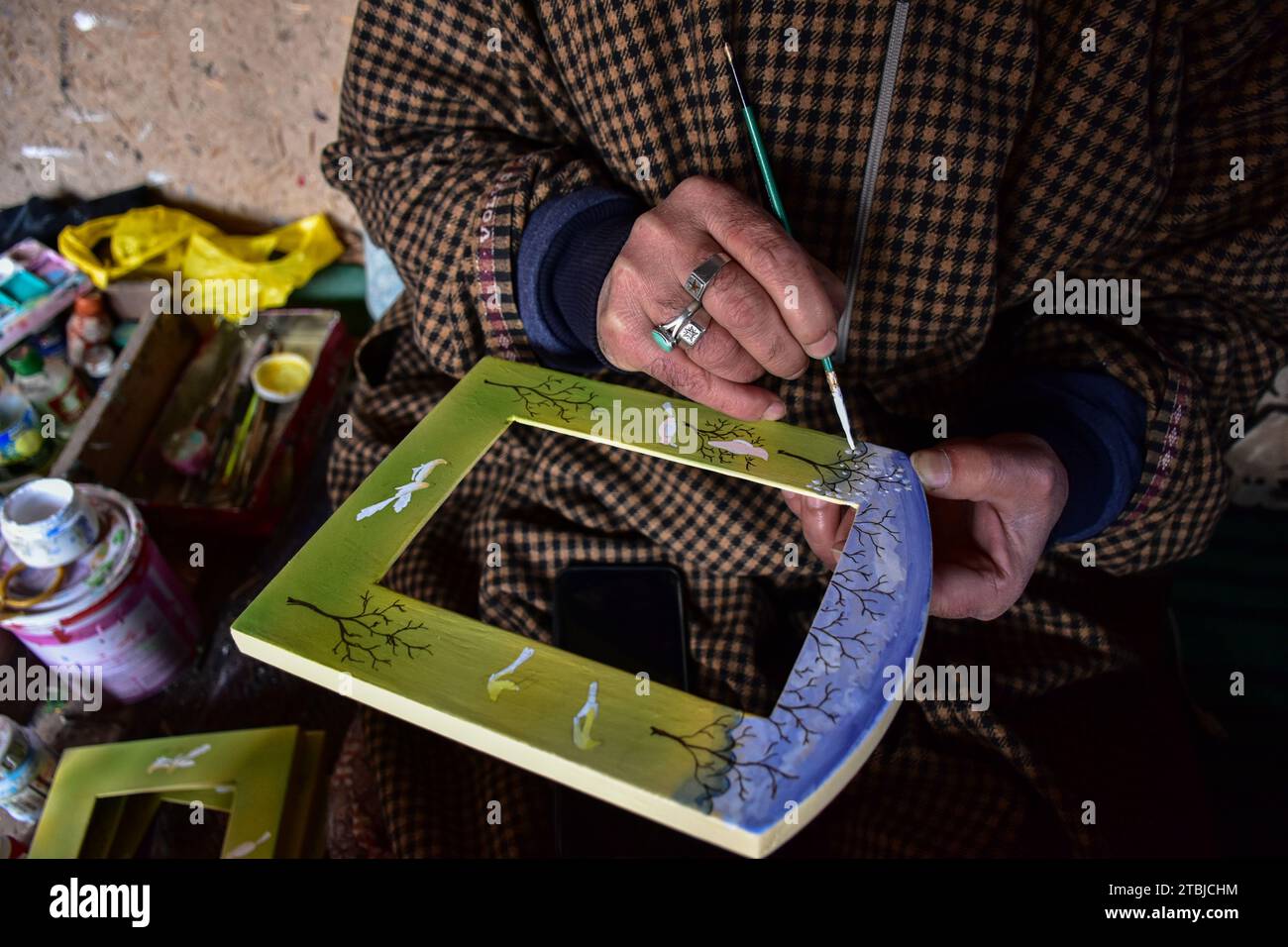 A Kashmiri artisan makes the final touches on a papier-mache product ...