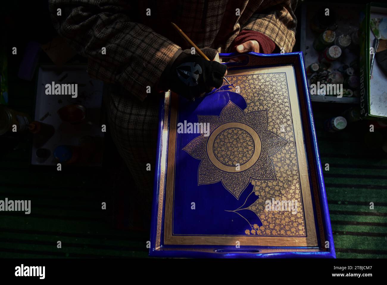 A Kashmiri artisan makes the final touches on a papier-mache product ...