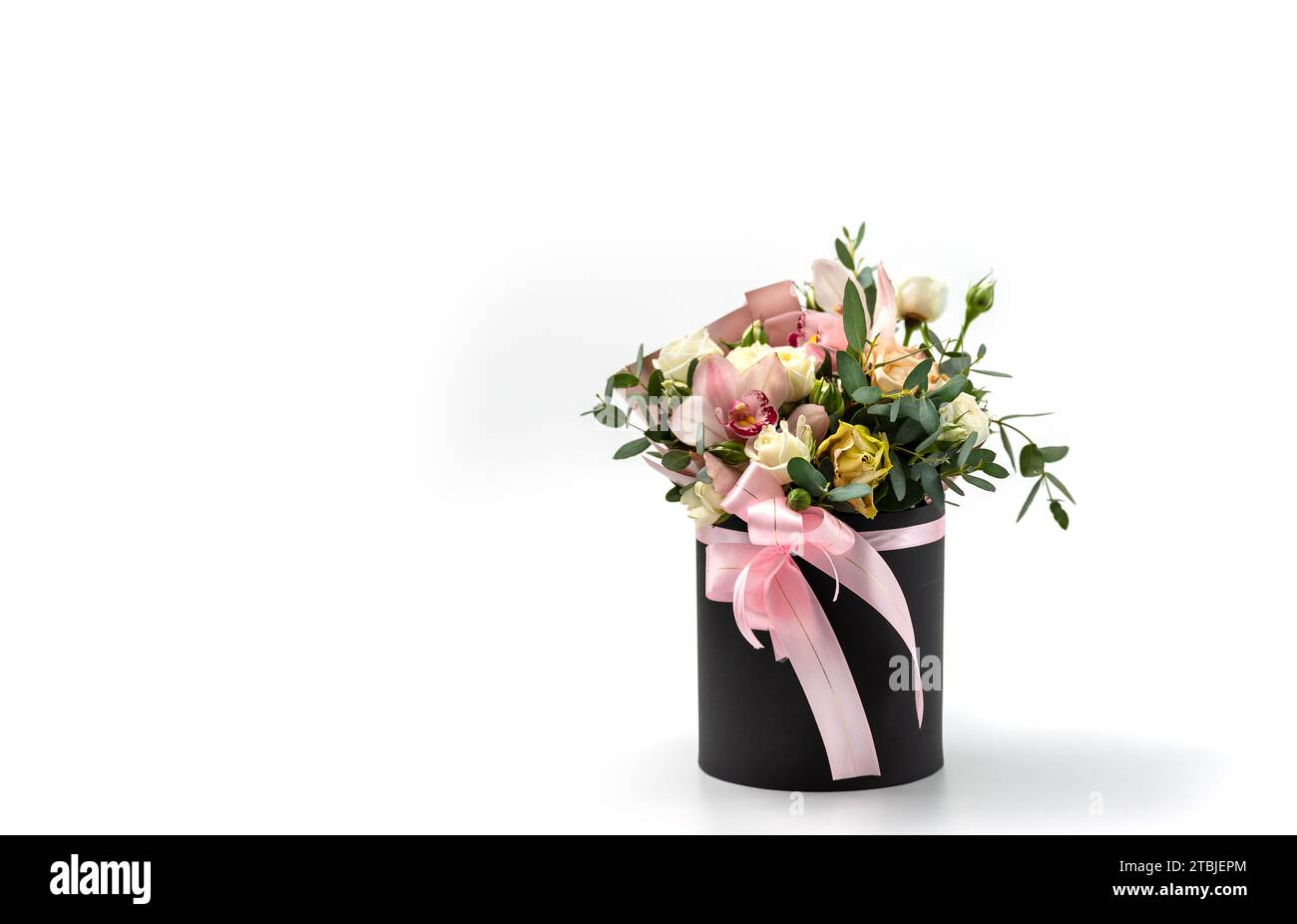 Flower arrangement in a hat box, a pot of roses and orchids on a white ...