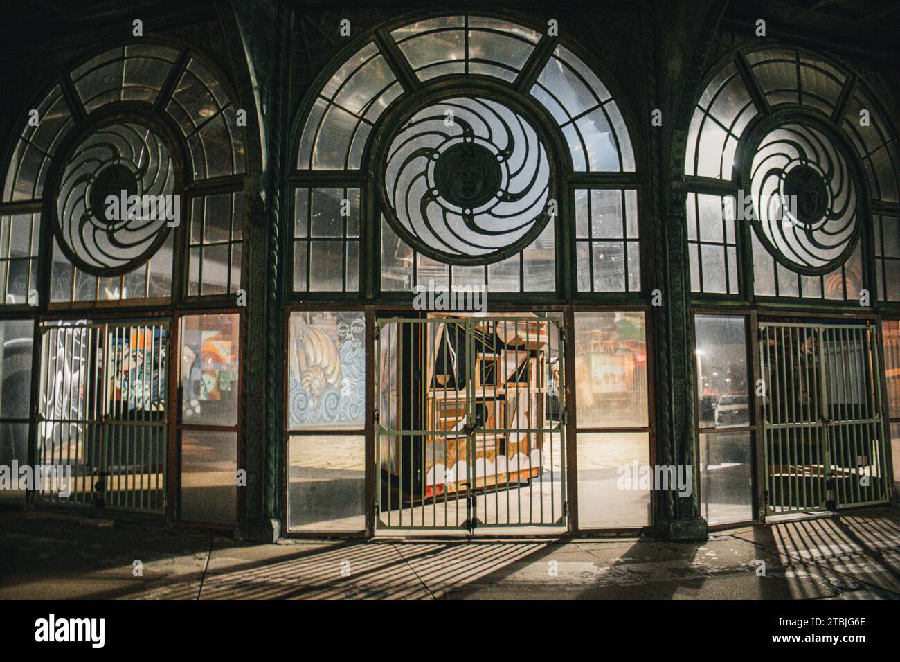 A shining metal gate stands illuminated in the evening light, a window ...