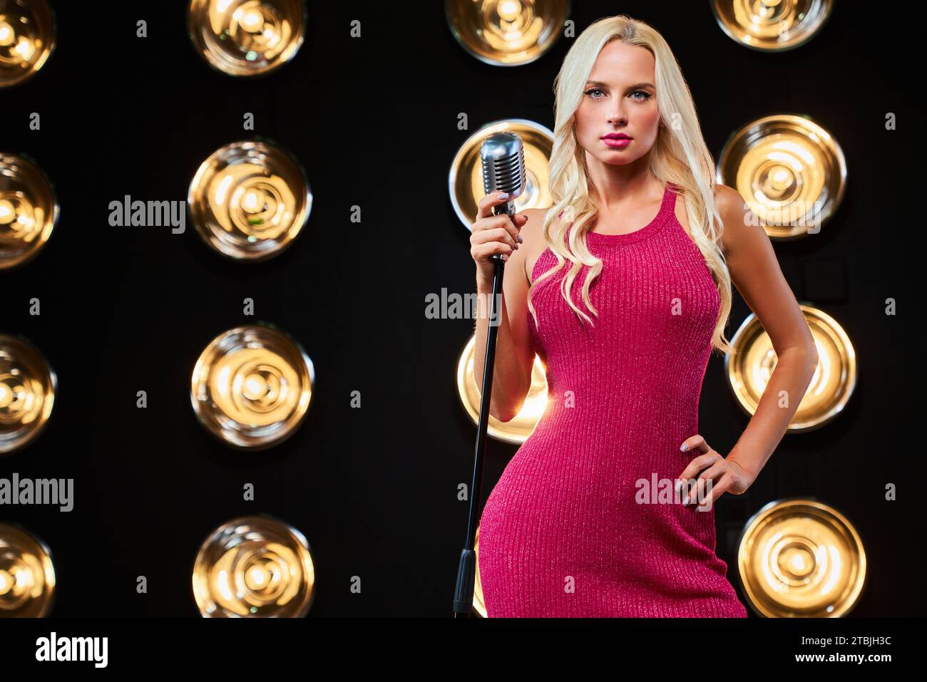 Attractive female singer in red glamorous dress, with microphone ...