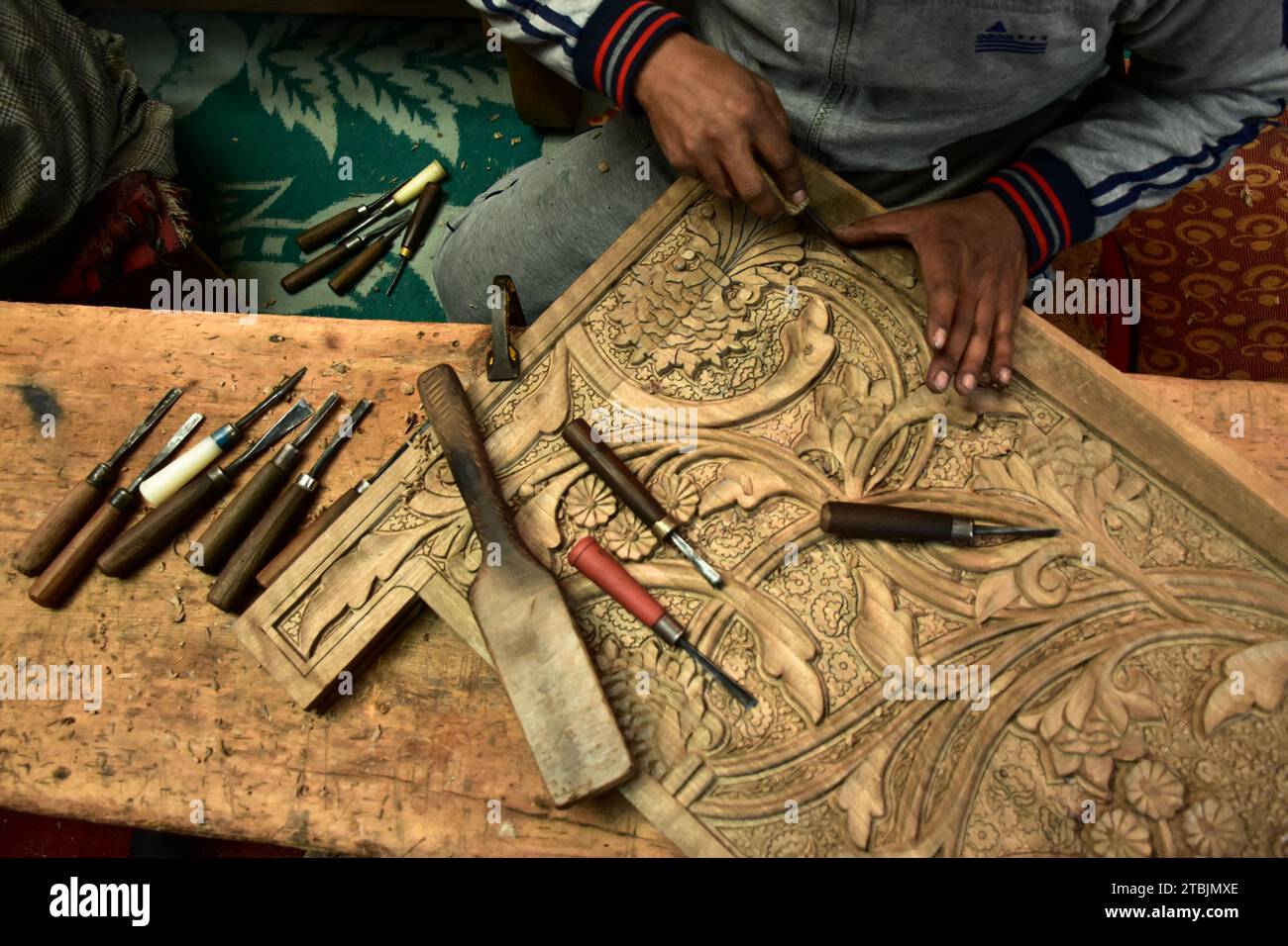 A Kashmiri artisan carves a handicraft item at a wood carving factory ...