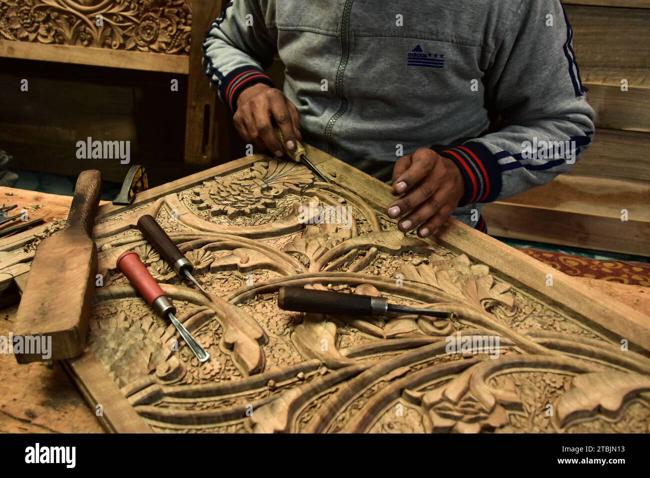 A Kashmiri artisan carves a handicraft item at a wood carving factory ...