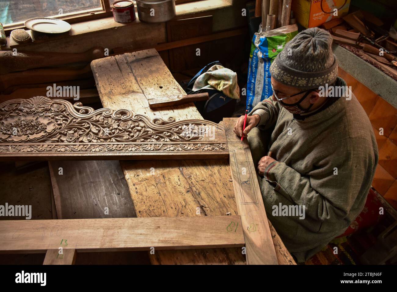 A Kashmiri artisan carves a handicraft item at a wood carving factory ...
