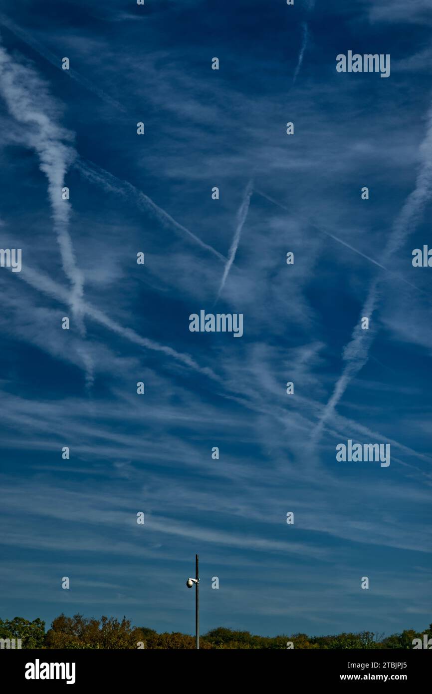 Multiple white contrails crossing each other are writing signs in the ...